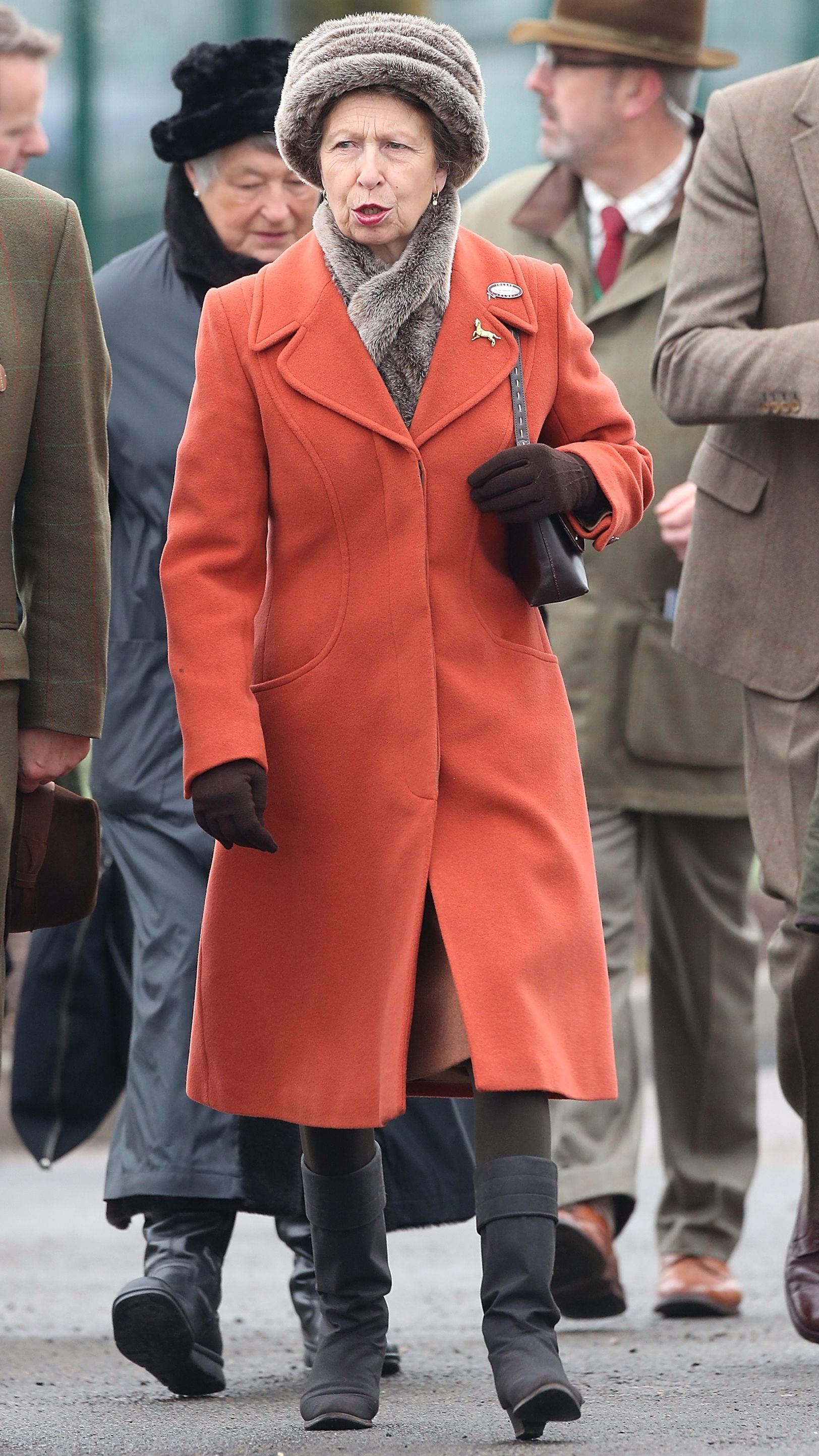 Princess Anne wrapped up in burnt orange coat, fluffy hat and boots ...