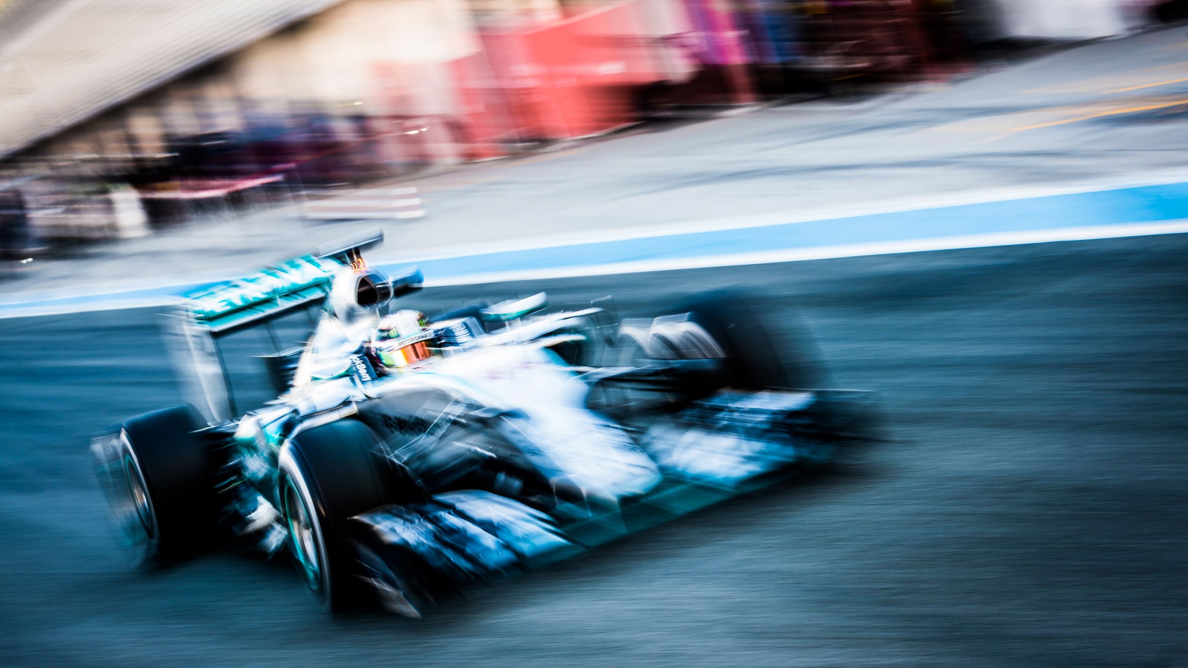 This vibrant action shot of Lewis Hamilton, captured creatively at 1/10 ...