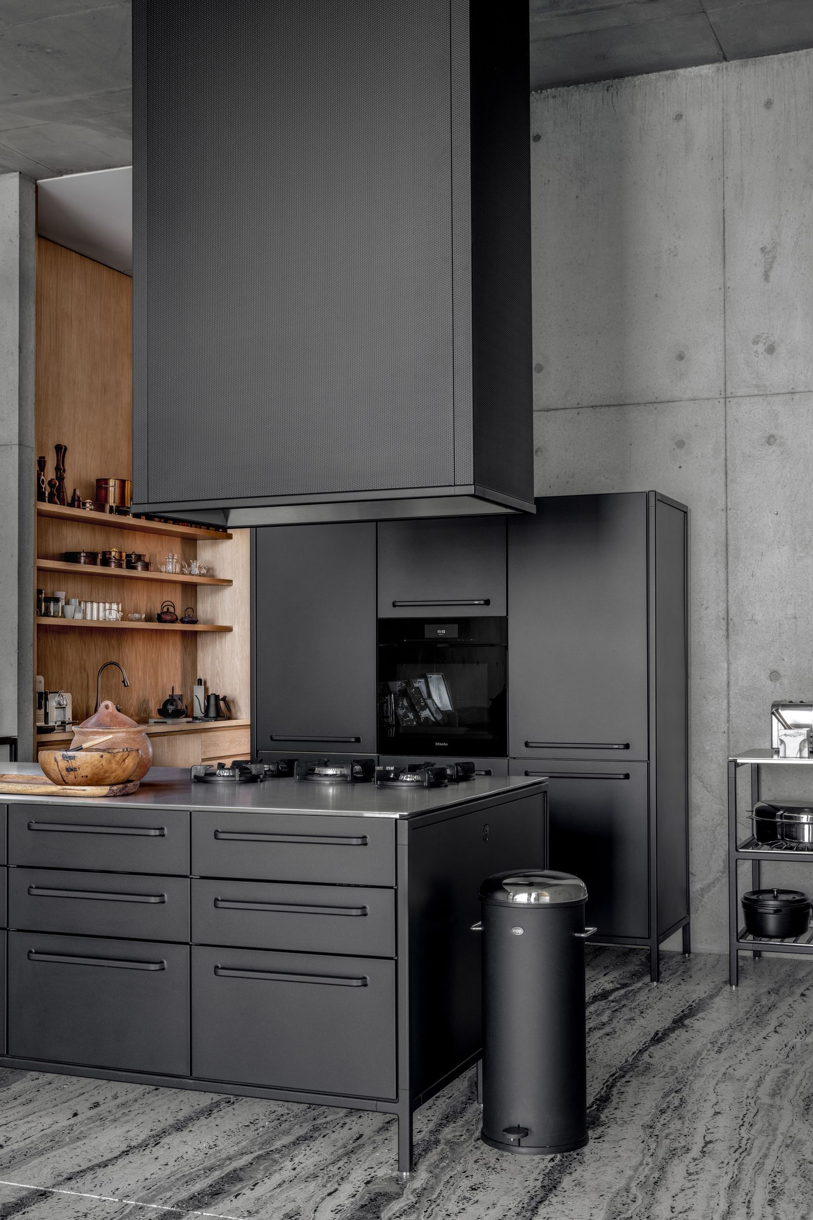 This brutalist home features a dramatic matte black kitchen | Livingetc