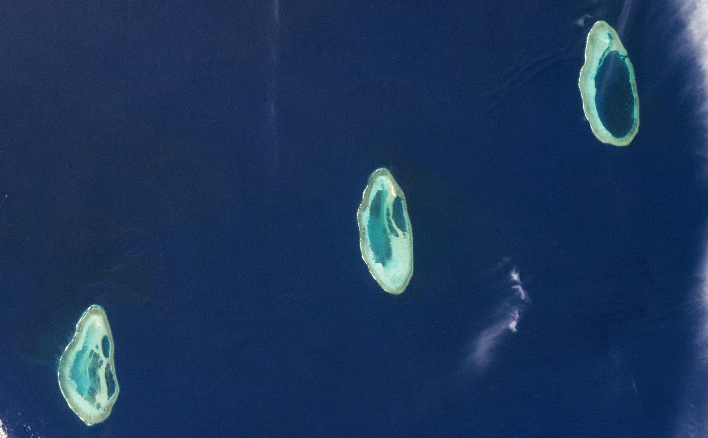 Perfect trio of prehistoric atolls shine like tropical gems off ...