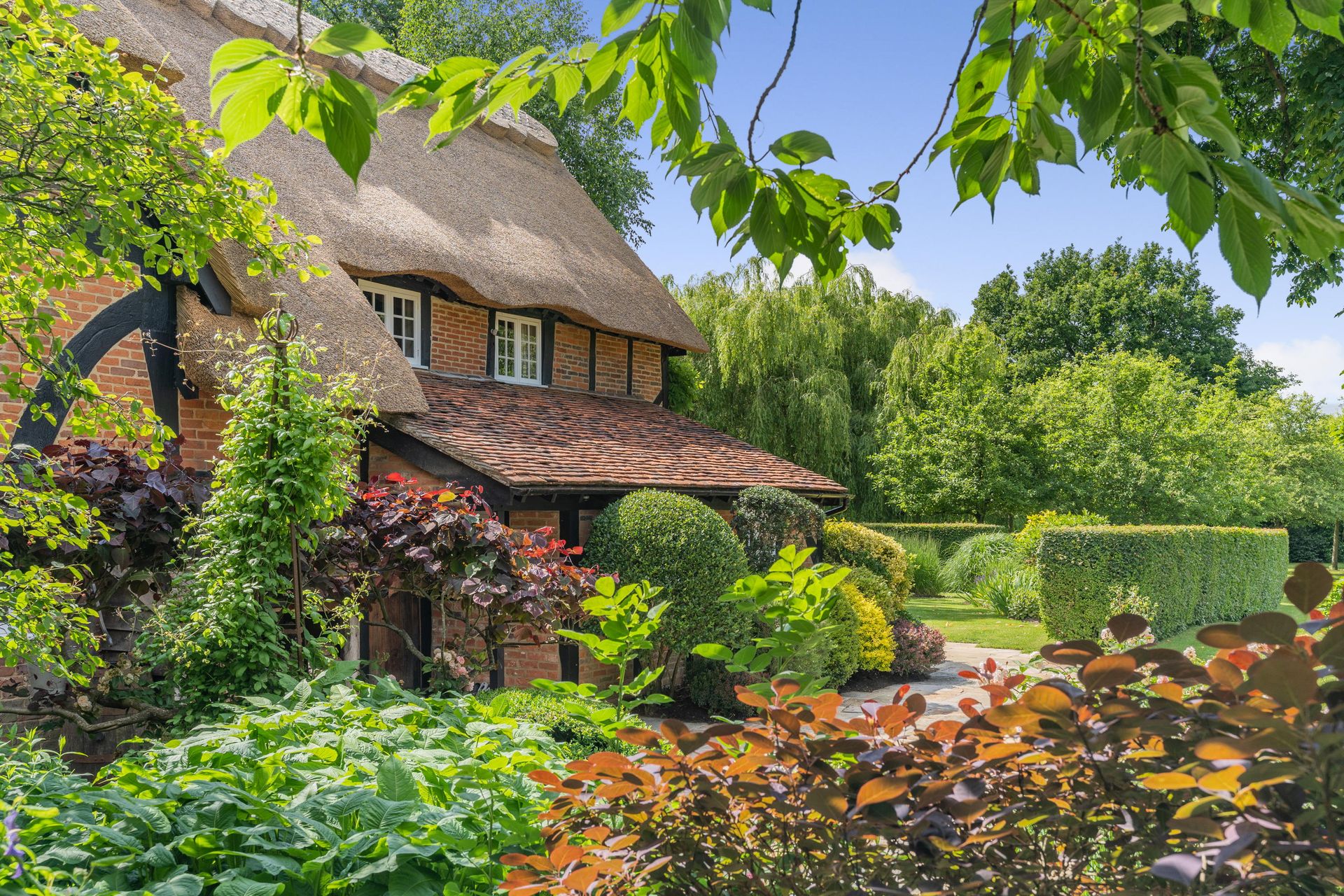 A billionaire's thatched cottage is for sale in Surrey, once owned by ...